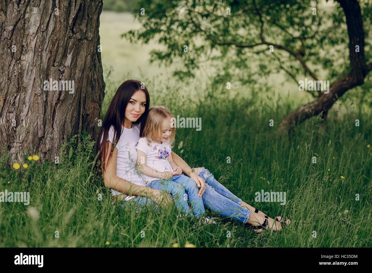 child near tree with mom Stock Photo - Alamy
