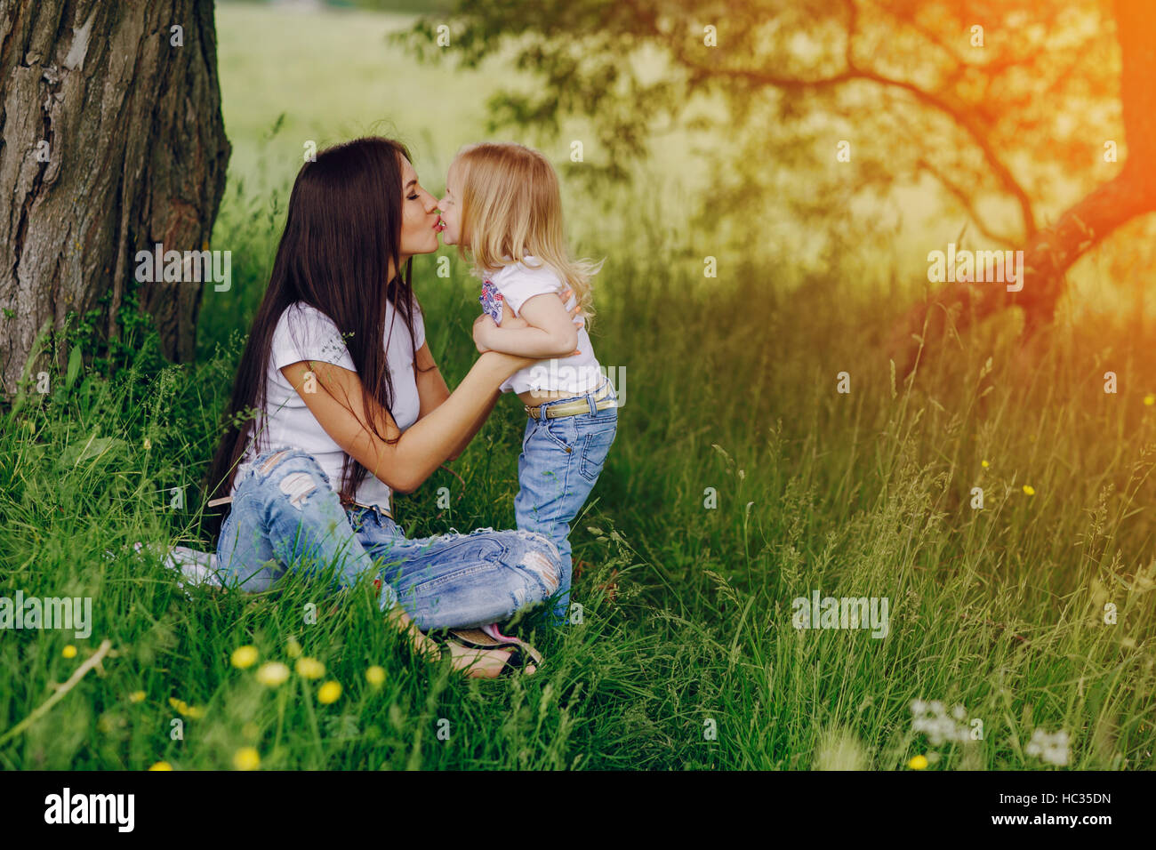 child near tree with mom Stock Photo - Alamy