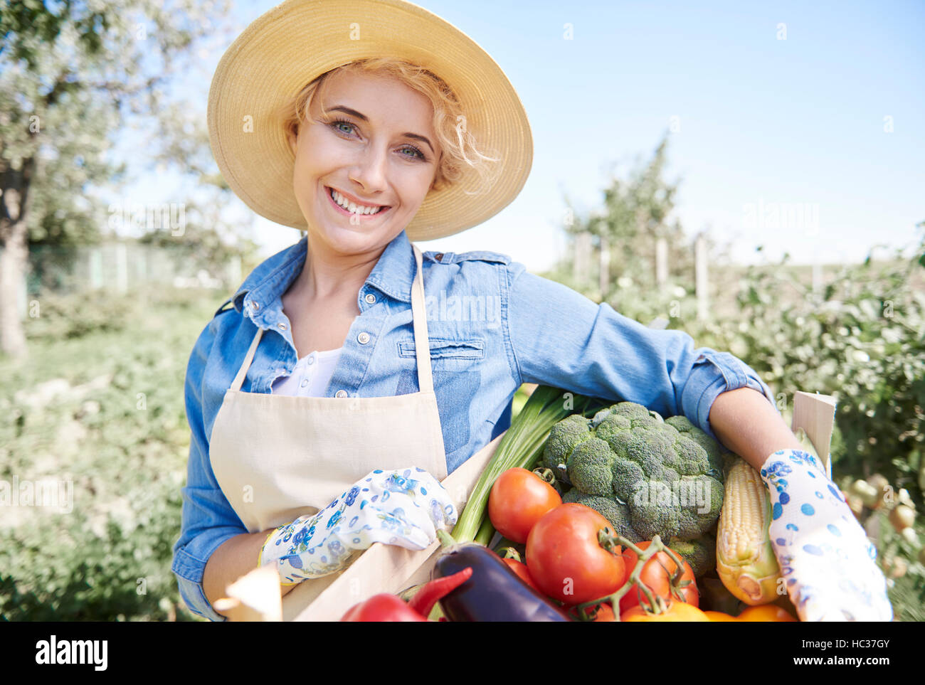 Portrait of smiling woman carrying crate Stock Photo - Alamy
