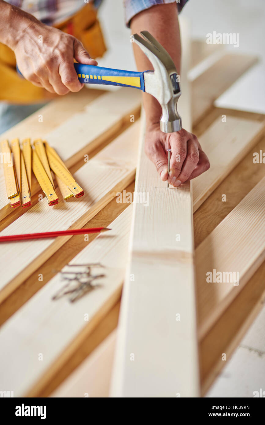 Carpenter with hammer hits wood Stock Photo - Alamy