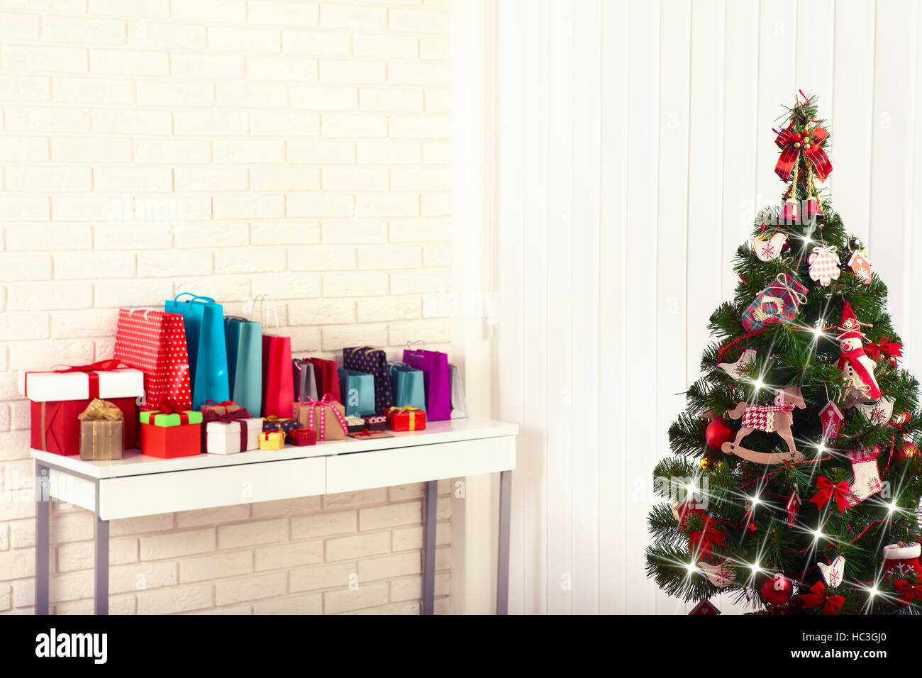 Christmas tree with present boxes over white brick wall Stock Photo - Alamy