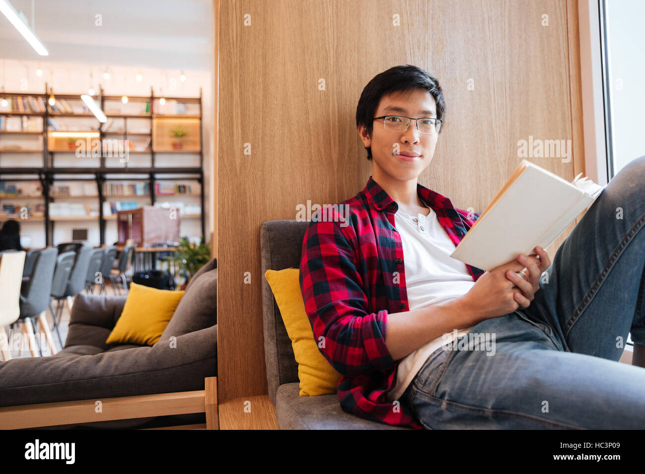 Image of happy asian student reading a book in university library ...