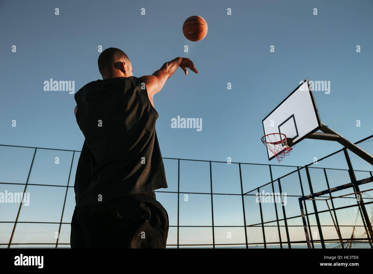 Portrait of a basketball player taking a jump shot on an outdoor ...