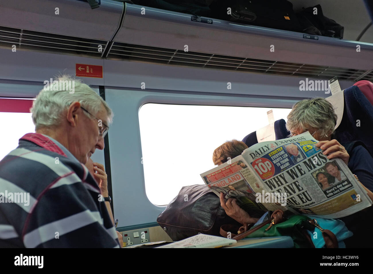 A couple on their 60's reading on a train Stock Photo - Alamy