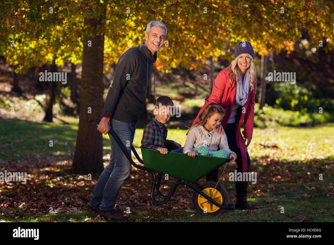 Happy family playing with the wheelbarrow Stock Photo - Alamy