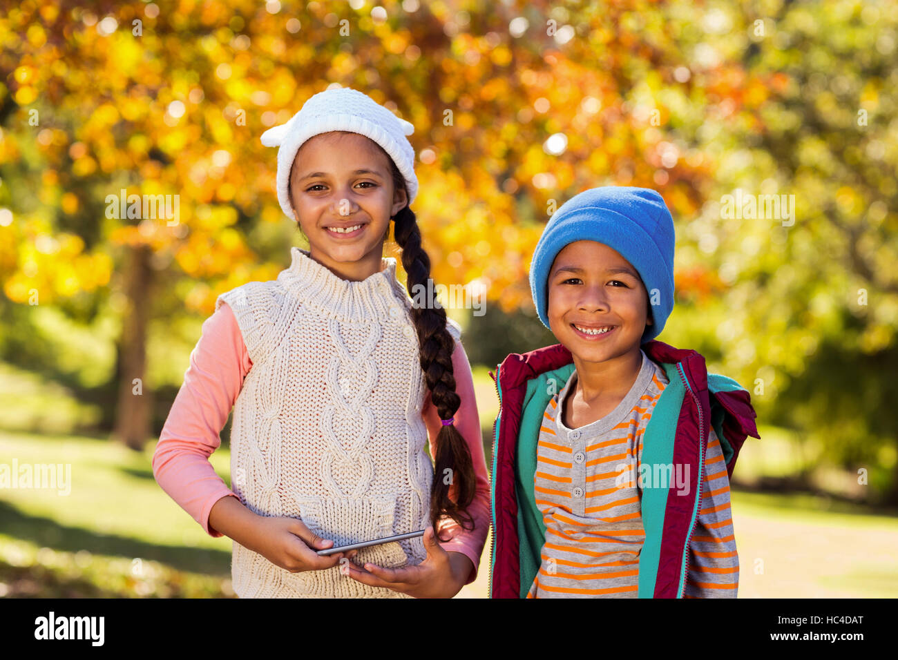 Portrait of happy siblings standing at park Stock Photo - Alamy