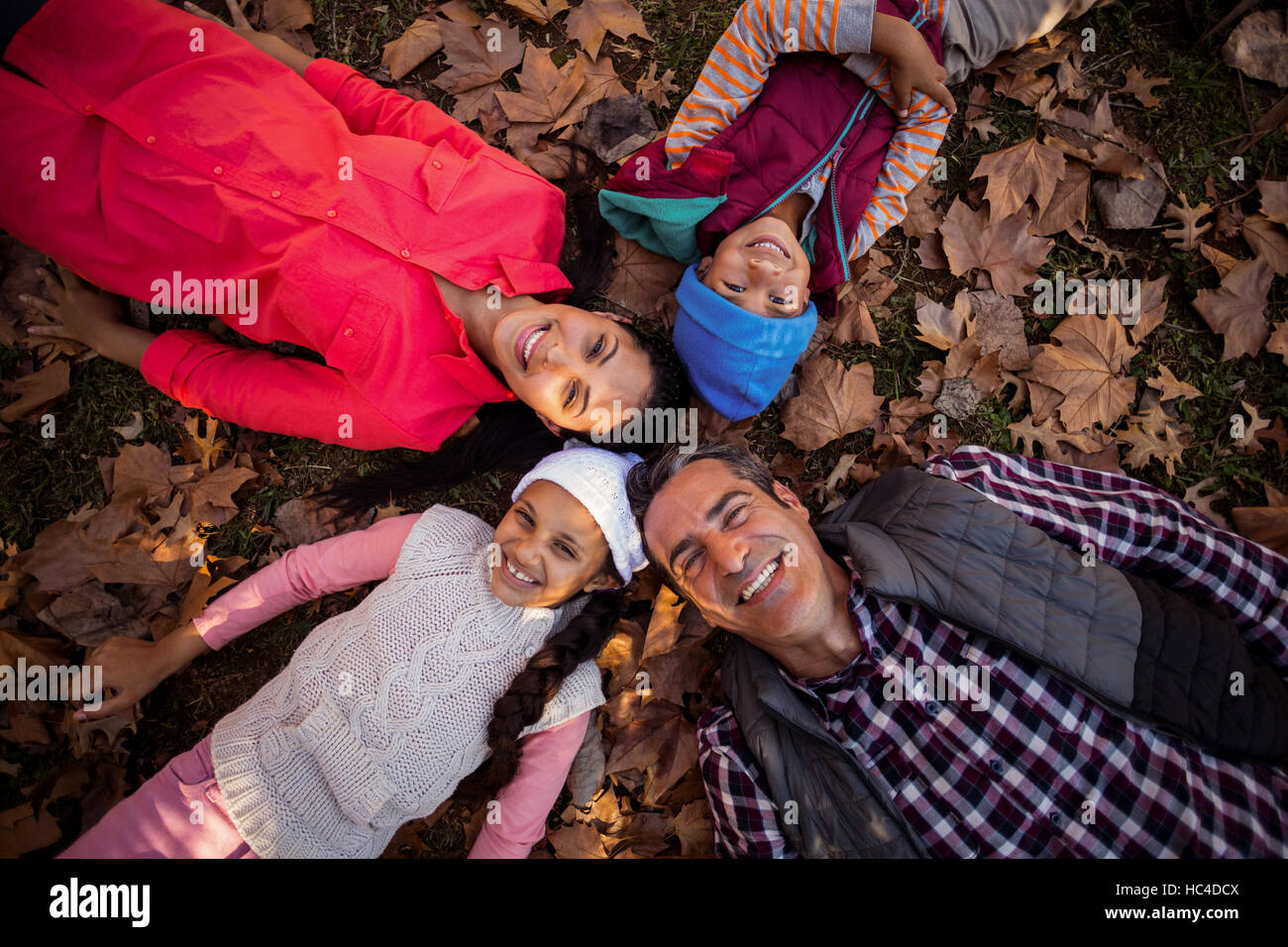 Happy family forming huddle while lying on field Stock Photo - Alamy