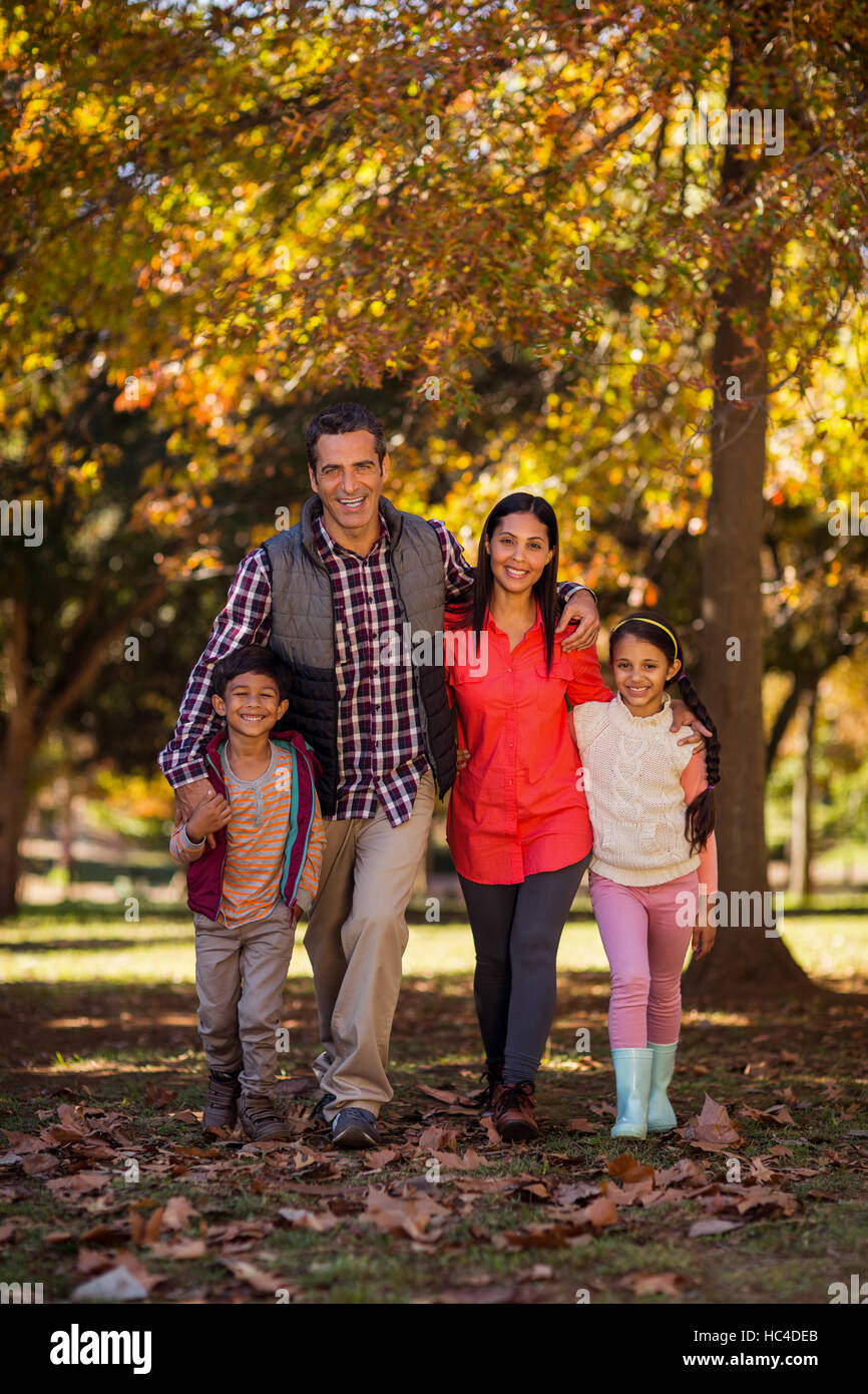 Portrait of smiling family walking at park Stock Photo - Alamy