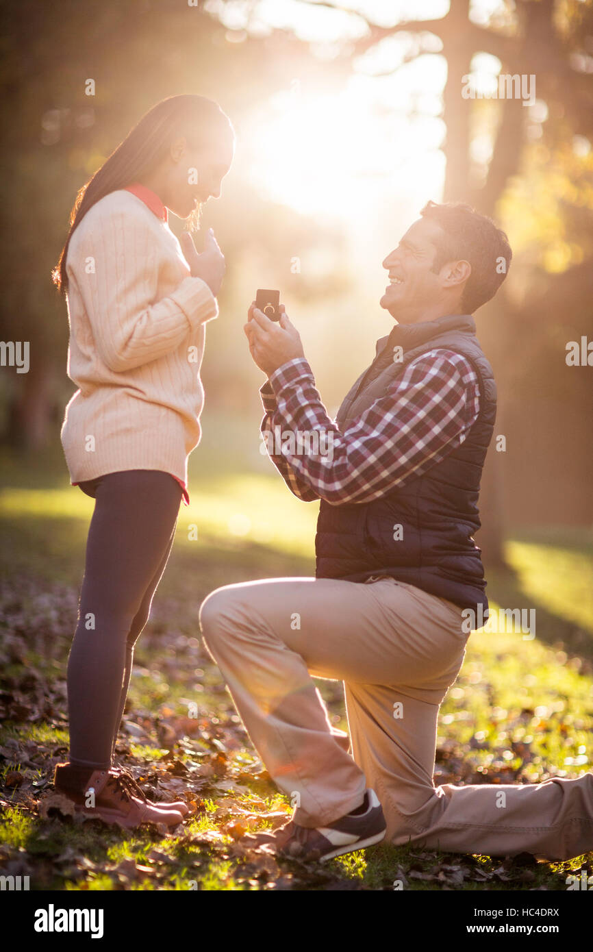 Man proposing woman at park Stock Photo - Alamy