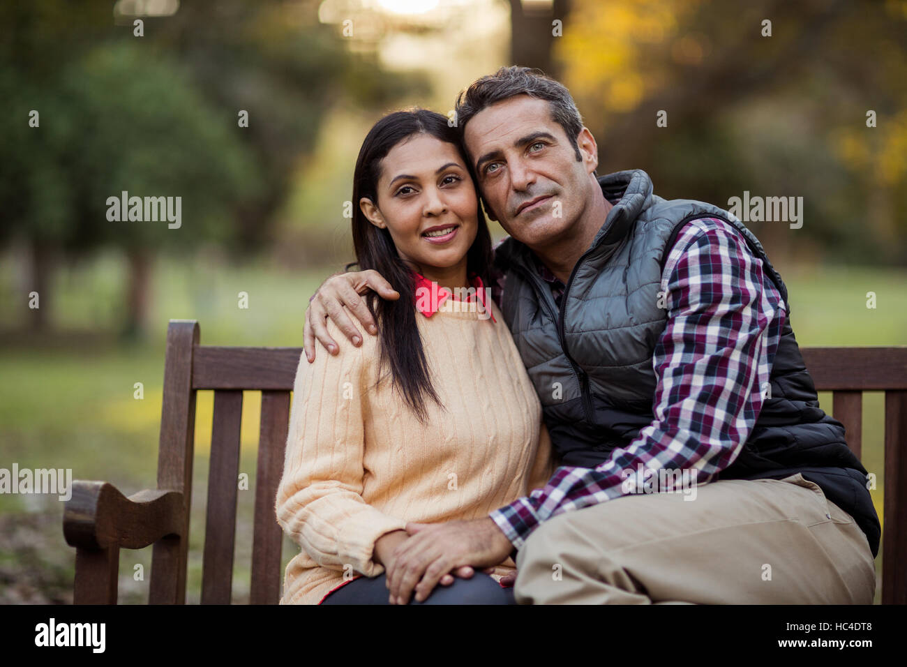 Couple sitting on bench Stock Photo - Alamy