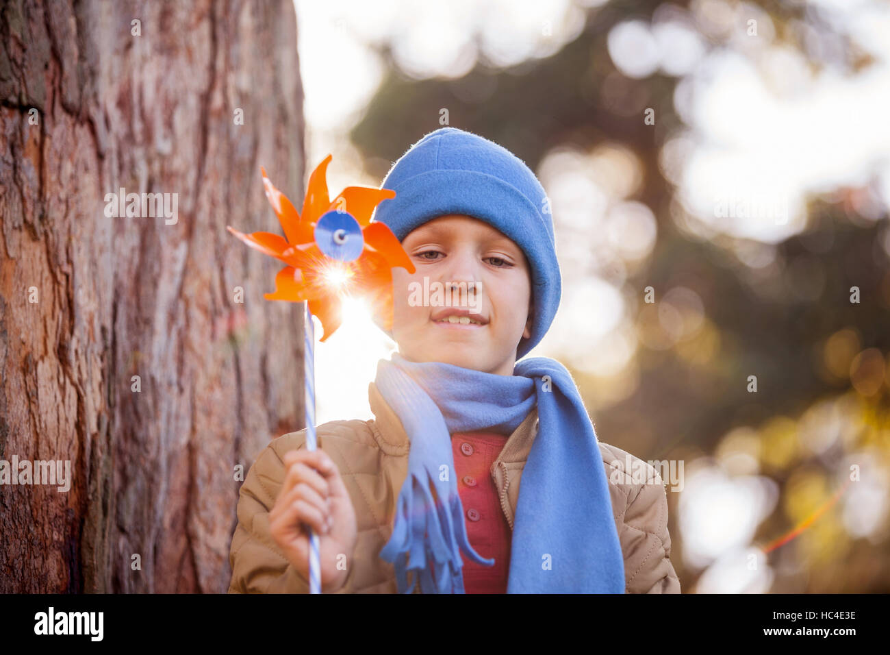 Low angle portrait of smiling boy holding pinwheel at park Stock Photo ...
