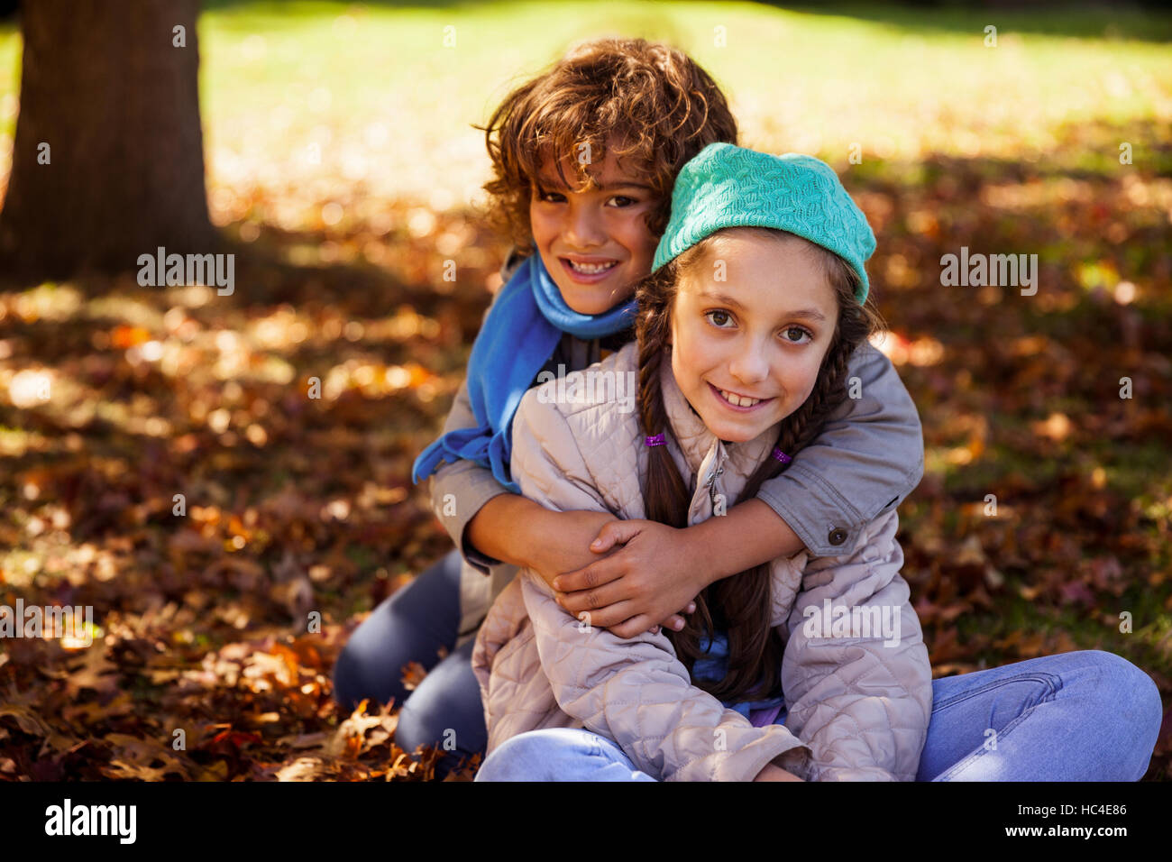 Smiling siblings embracing in park Stock Photo - Alamy