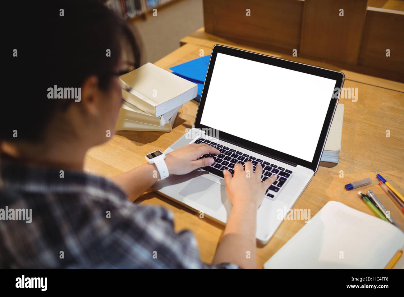 Female student using laptop in library Stock Photo - Alamy
