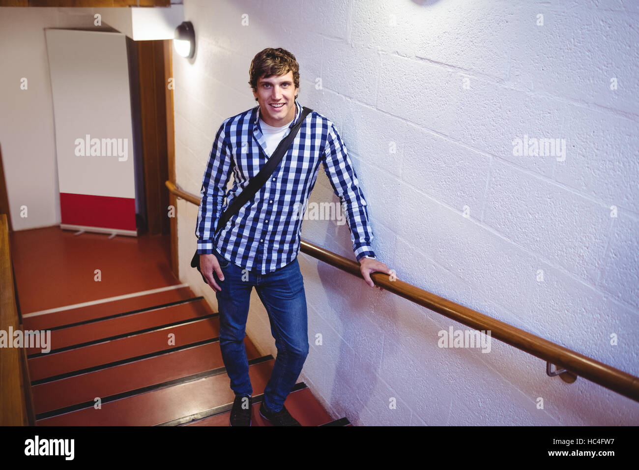 Student standing on staircase Stock Photo - Alamy