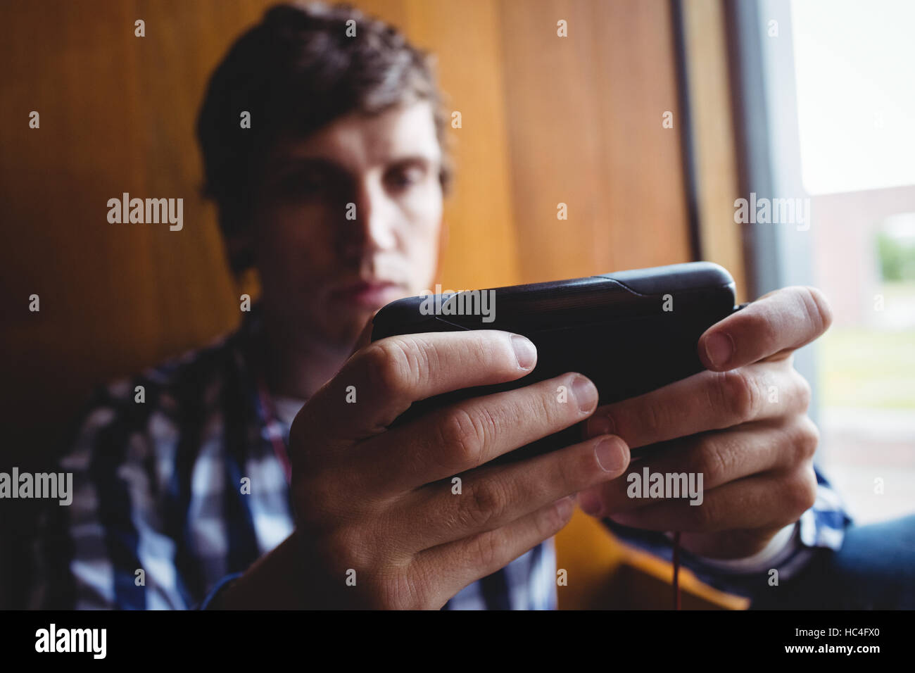 Student using mobile phone near window Stock Photo - Alamy