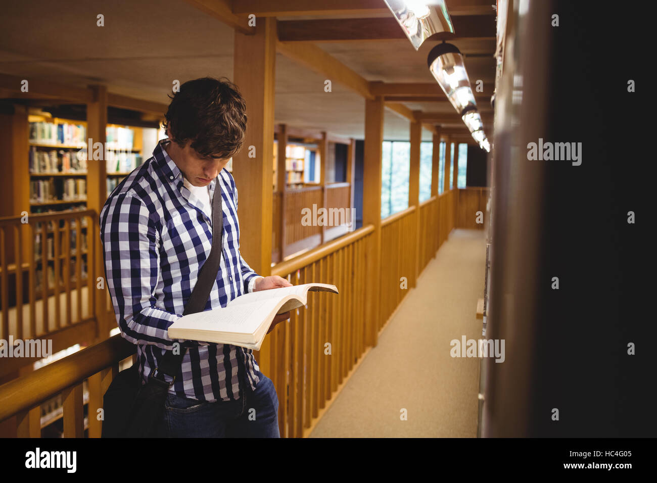 Student reading book in college library Stock Photo - Alamy