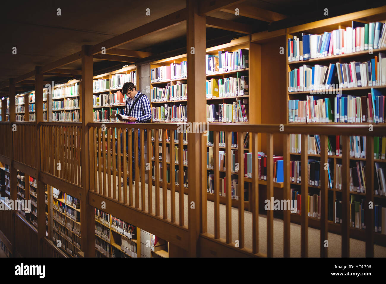Student reading book in college library Stock Photo - Alamy