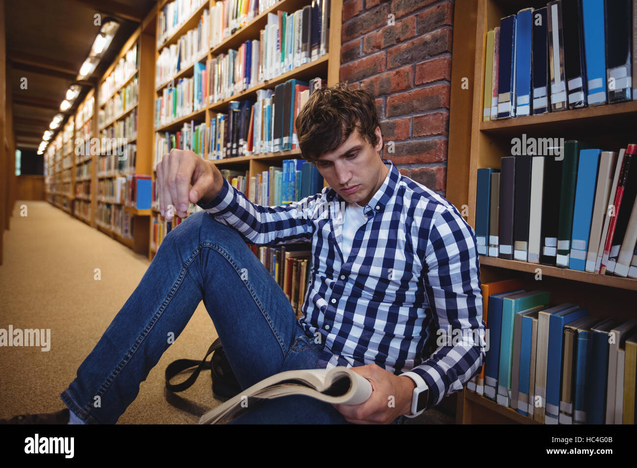 Student reading book in college library Stock Photo - Alamy