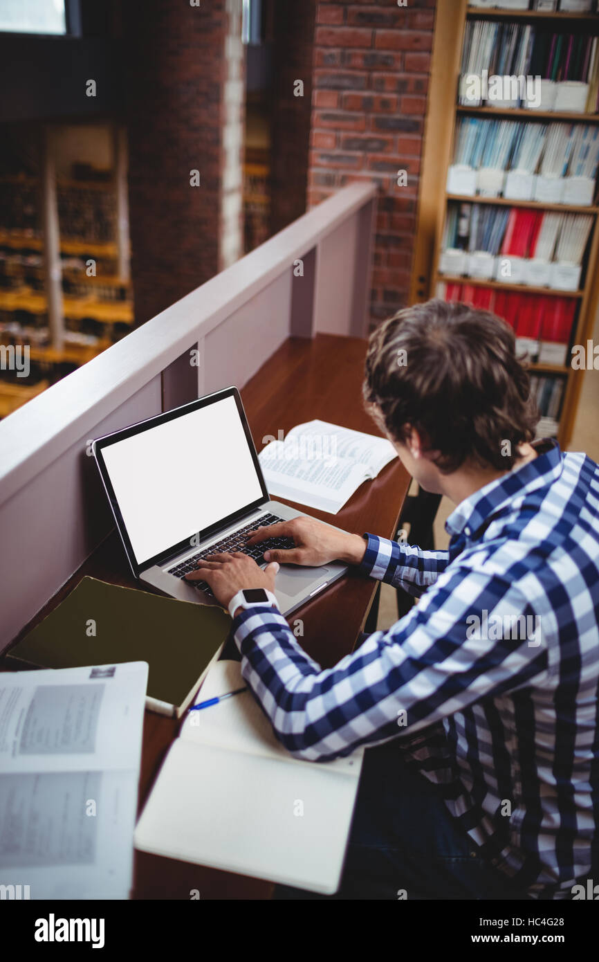 Student using laptop in library Stock Photo - Alamy
