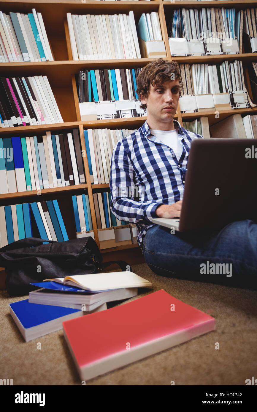 Student using laptop in library Stock Photo - Alamy