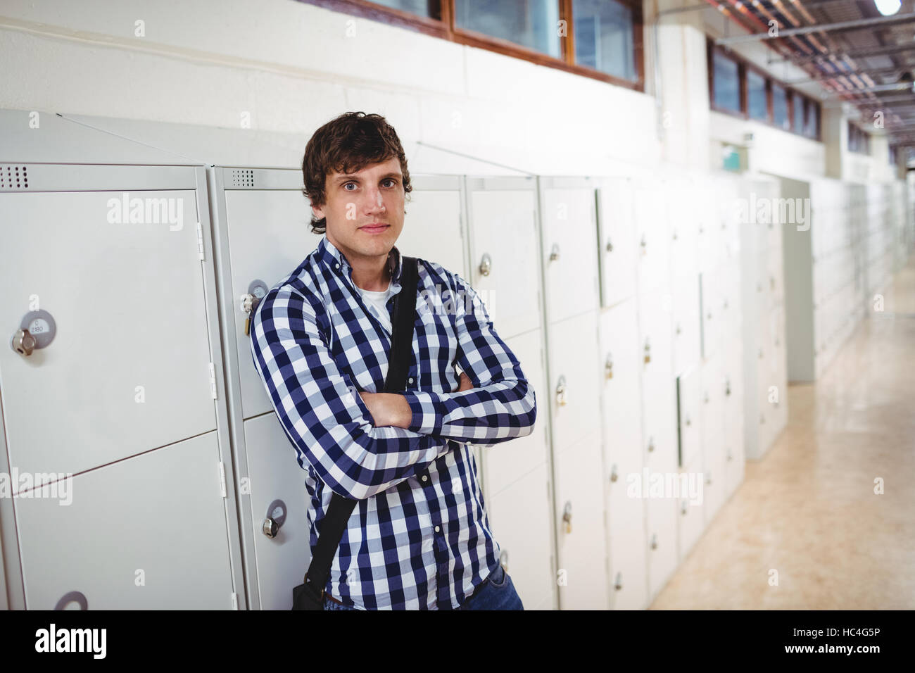 Portrait of student standing with arms crossed in locker room Stock ...