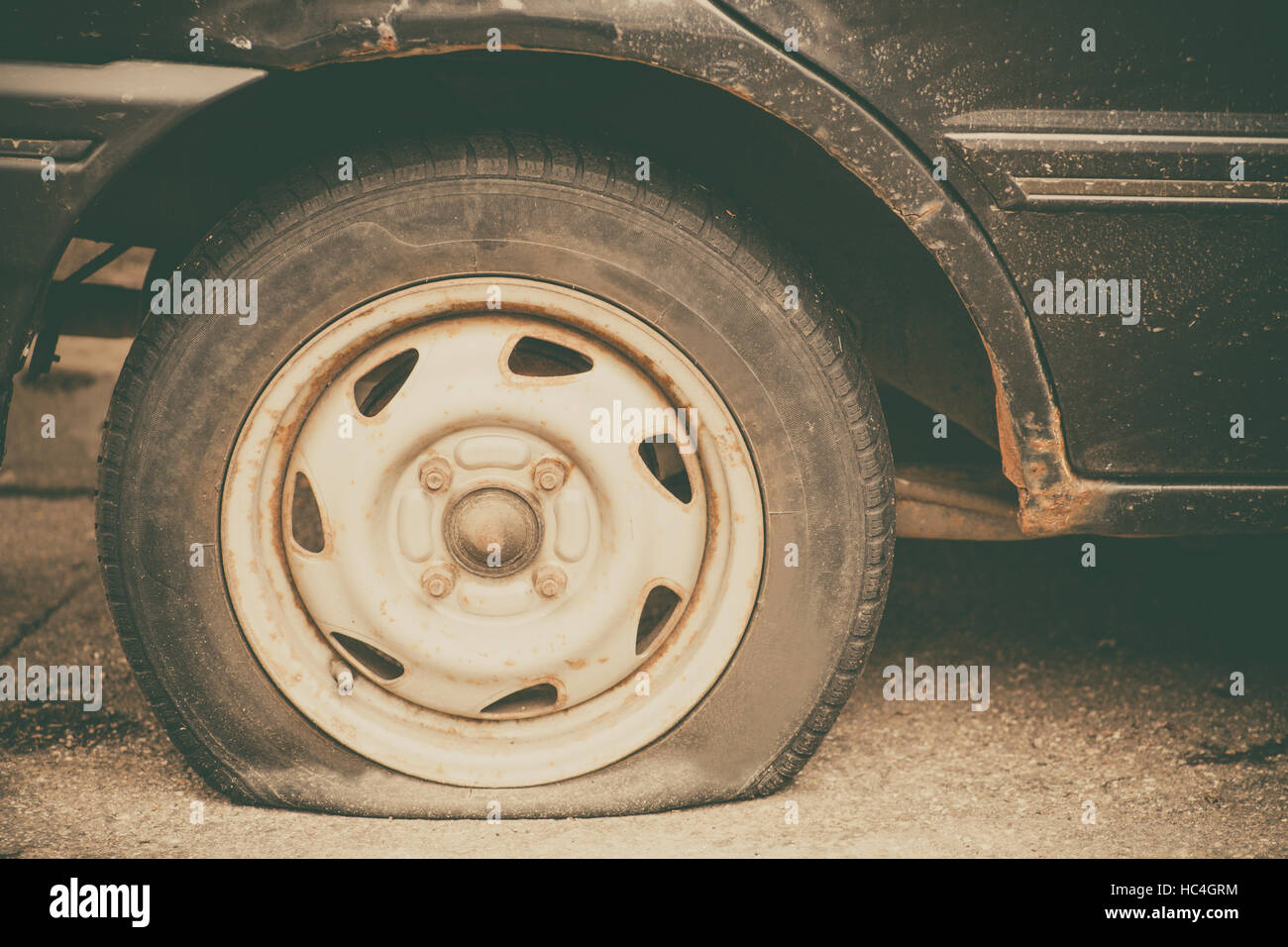 Close up shot of a car with a flat tire Stock Photo - Alamy