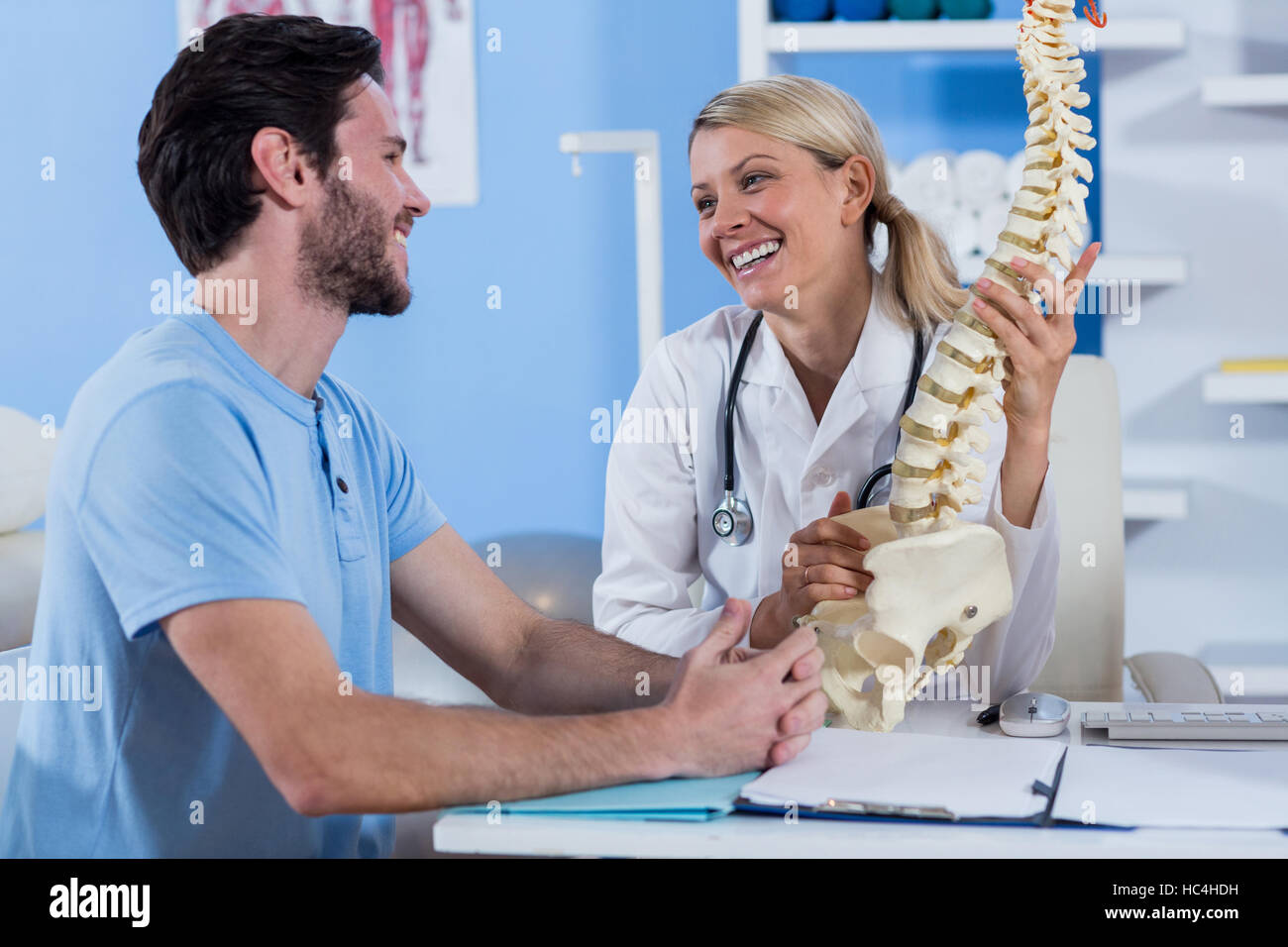 Physiotherapist explaining the spine model to patient Stock Photo - Alamy