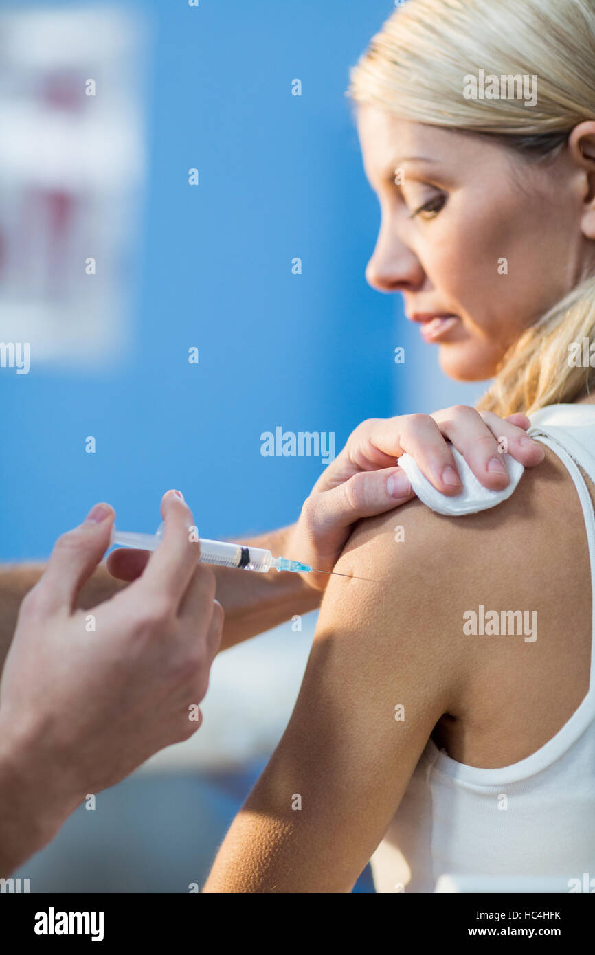 Physiotherapist injecting female patient Stock Photo - Alamy