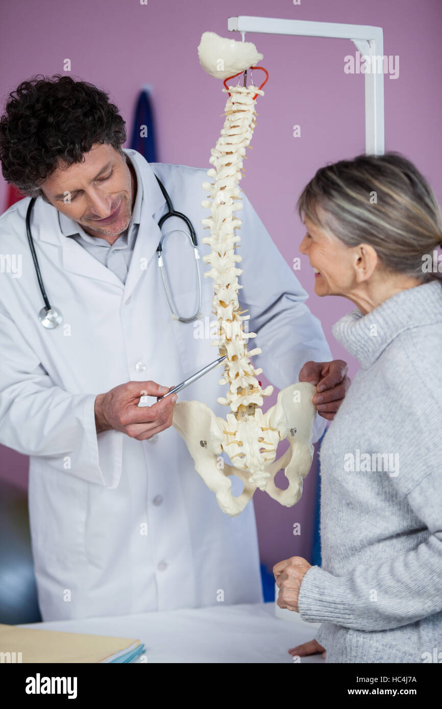 Physiotherapist explaining the spine model to patient Stock Photo - Alamy