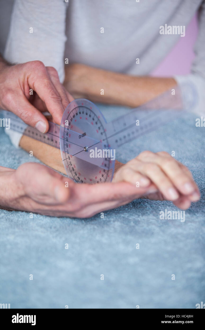 Physiotherapist measuring patient hand with goniometer Stock Photo - Alamy
