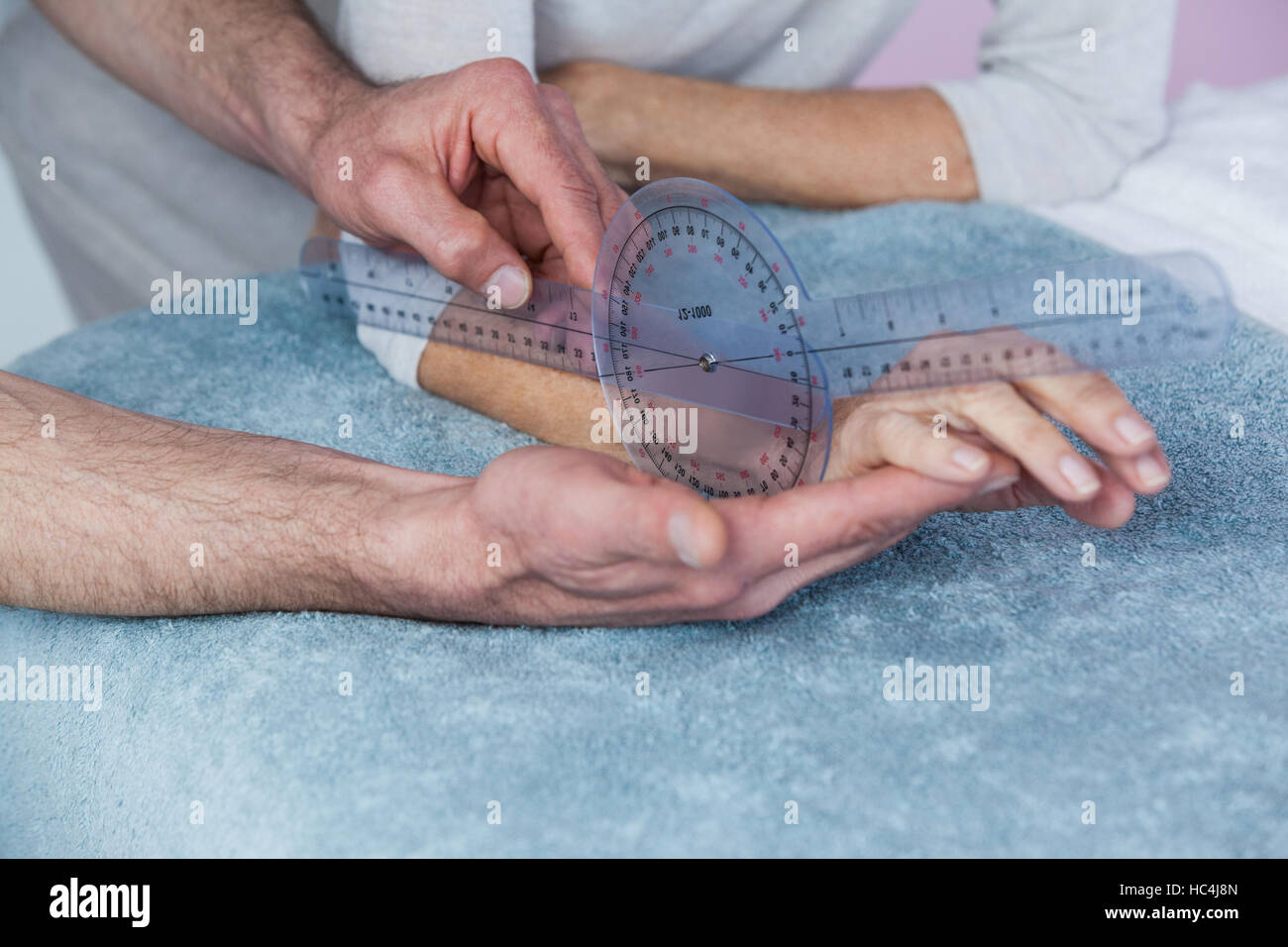 Physiotherapist measuring patient hand with goniometer Stock Photo - Alamy