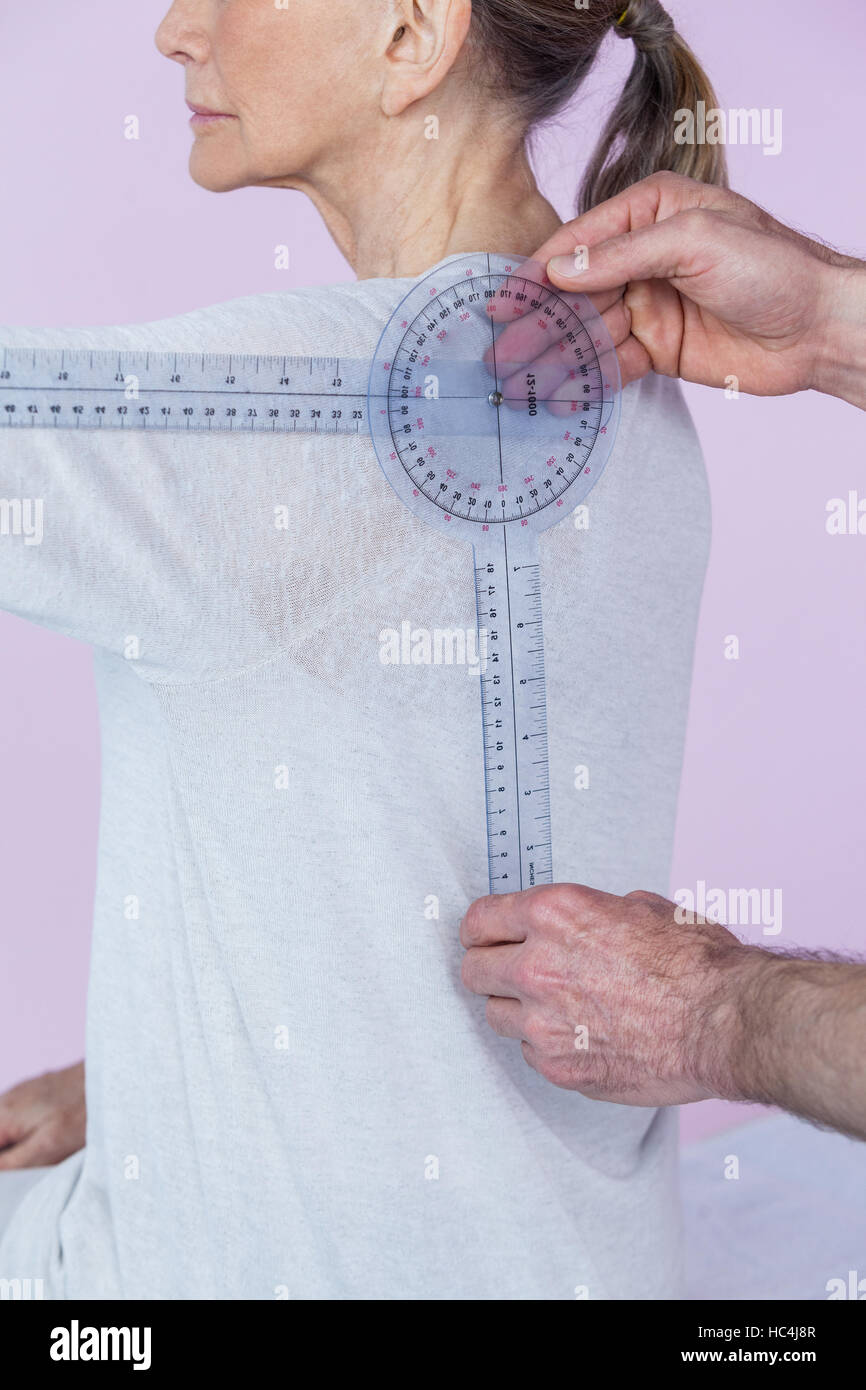 Physiotherapist measuring female patients back with medical ruler Stock ...