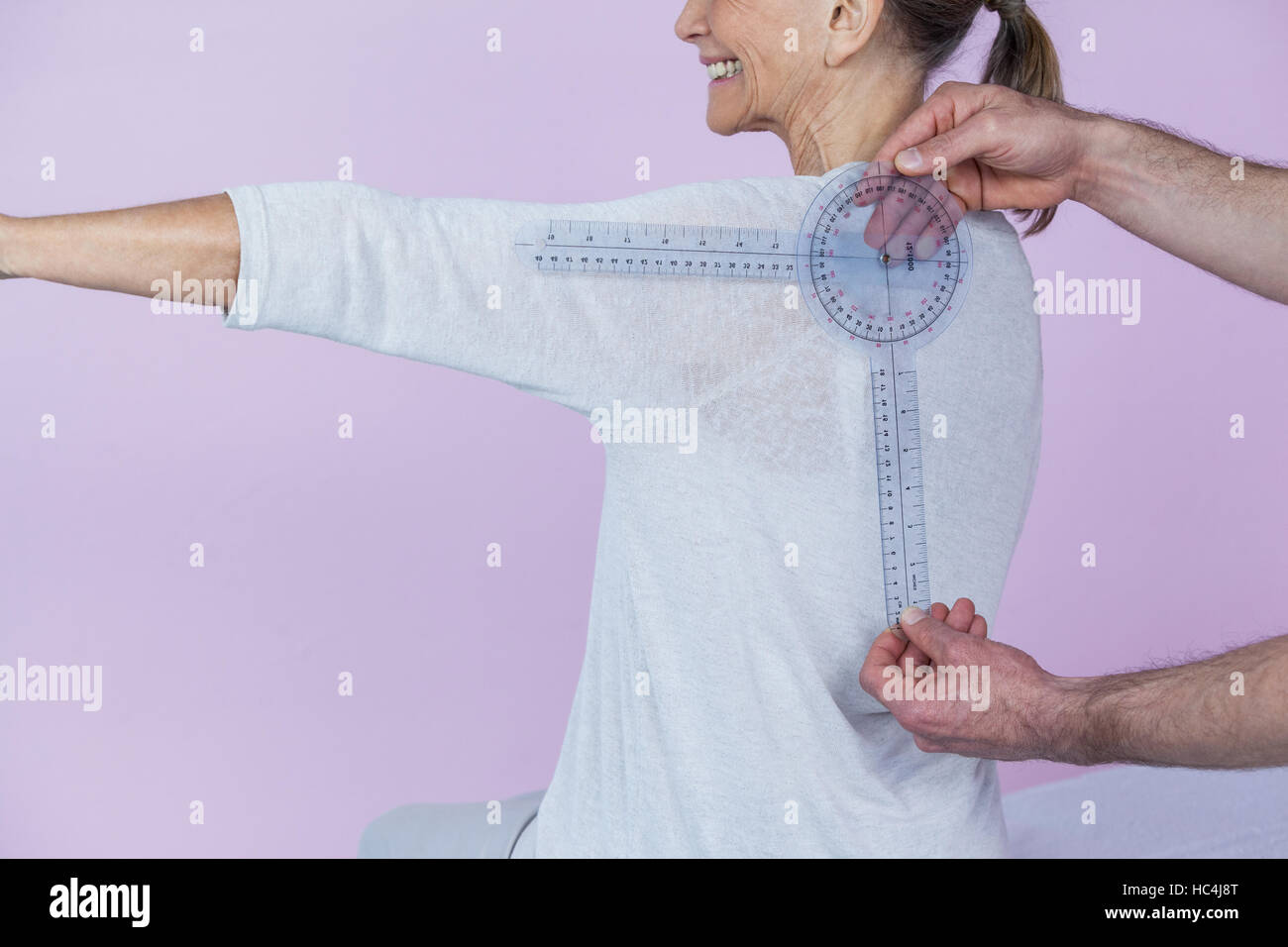Physiotherapist measuring female patients back with medical ruler Stock ...