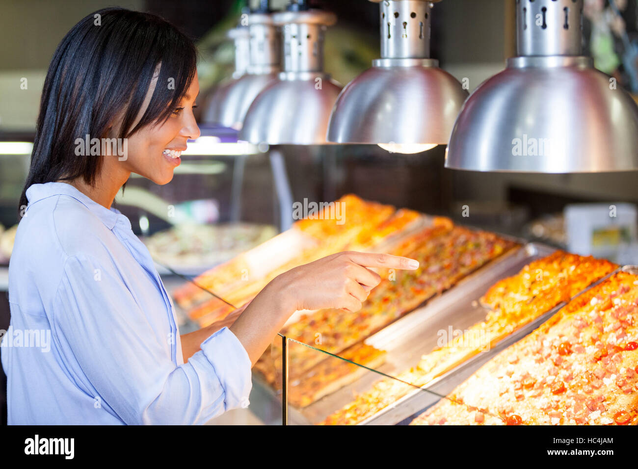 Excited woman pointing at snacks in disp Stock Photo - Alamy