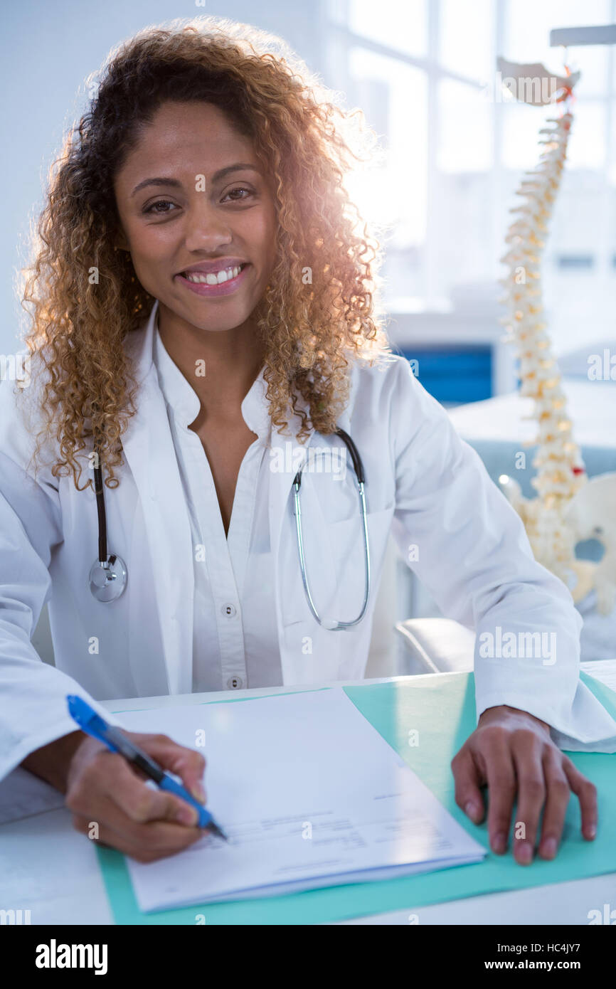 Smiling physiotherapist writing a report Stock Photo - Alamy