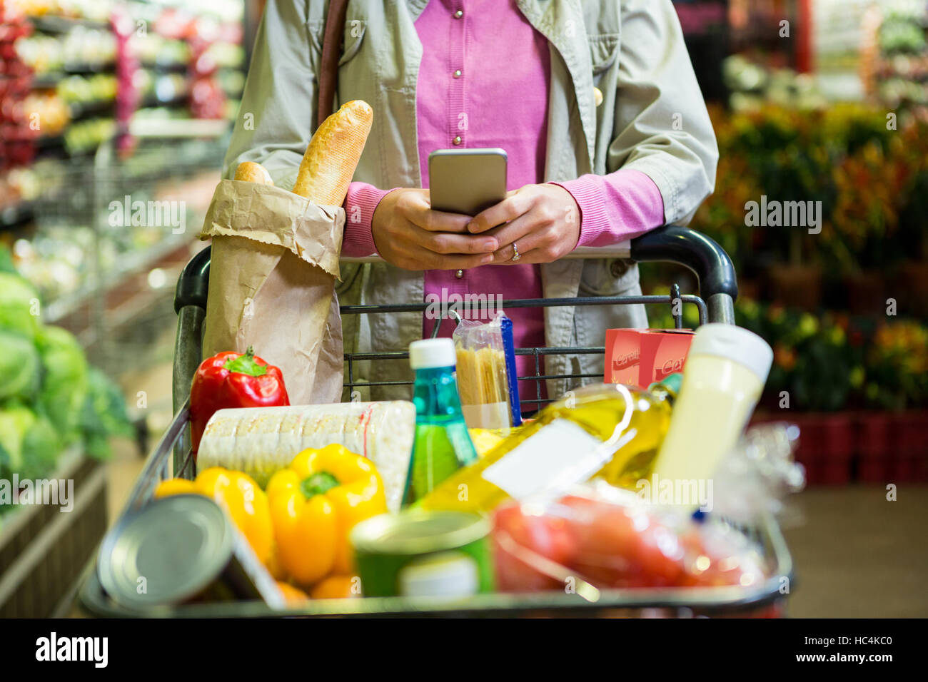 Woman using mobile phone while shopping Stock Photo - Alamy
