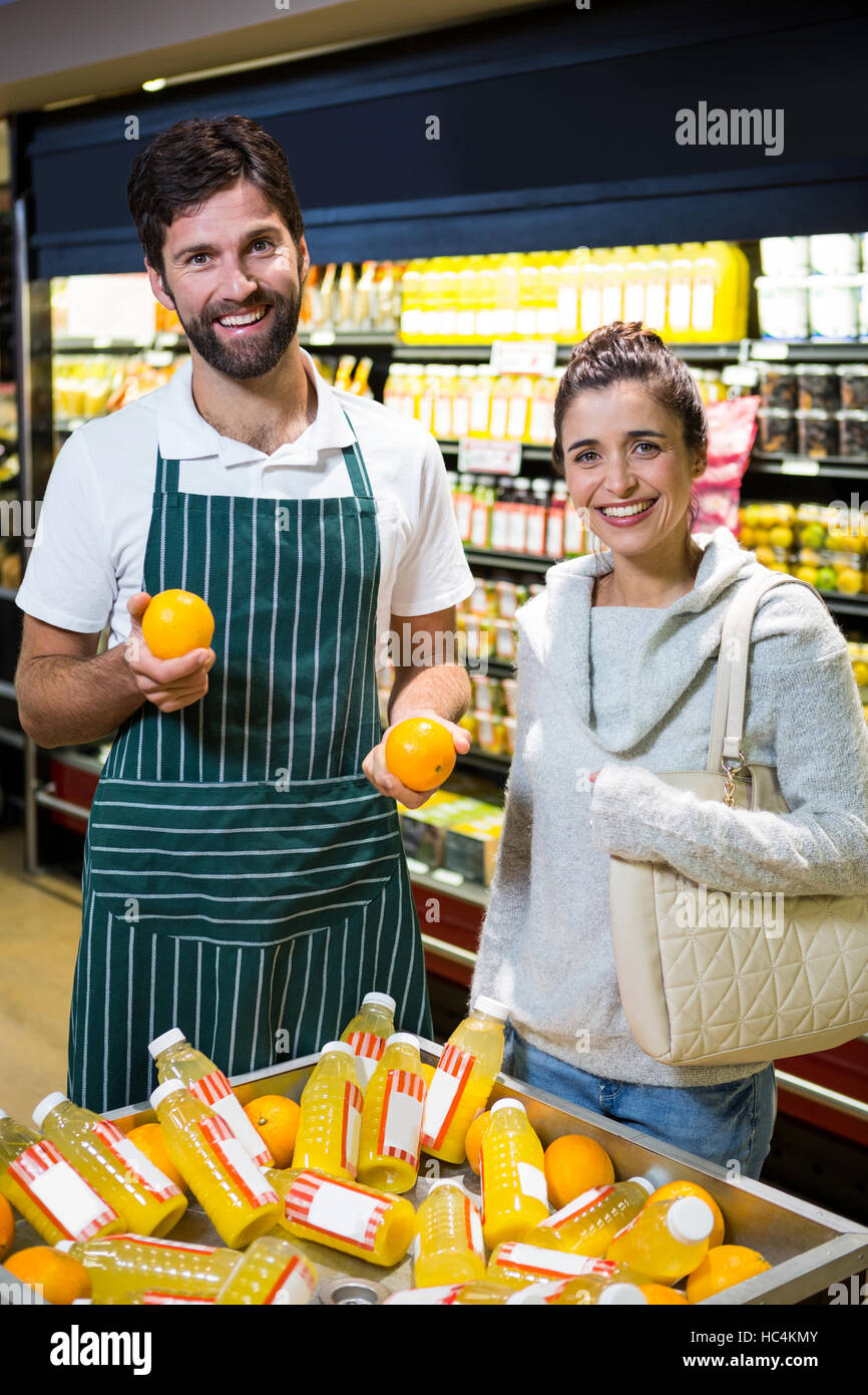 Smiling male staff assisting a woman with grocery shopping Stock Photo ...