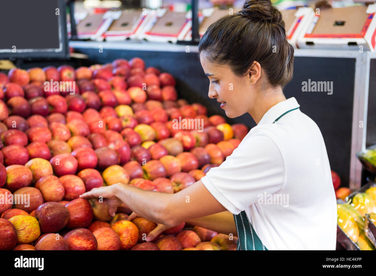 Female staff arranging fruits in organic section Stock Photo - Alamy