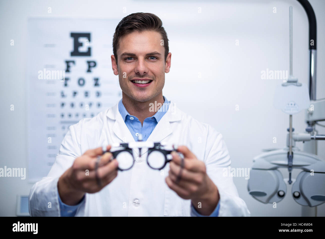 Smiling optometrist holding messbrille Stock Photo - Alamy