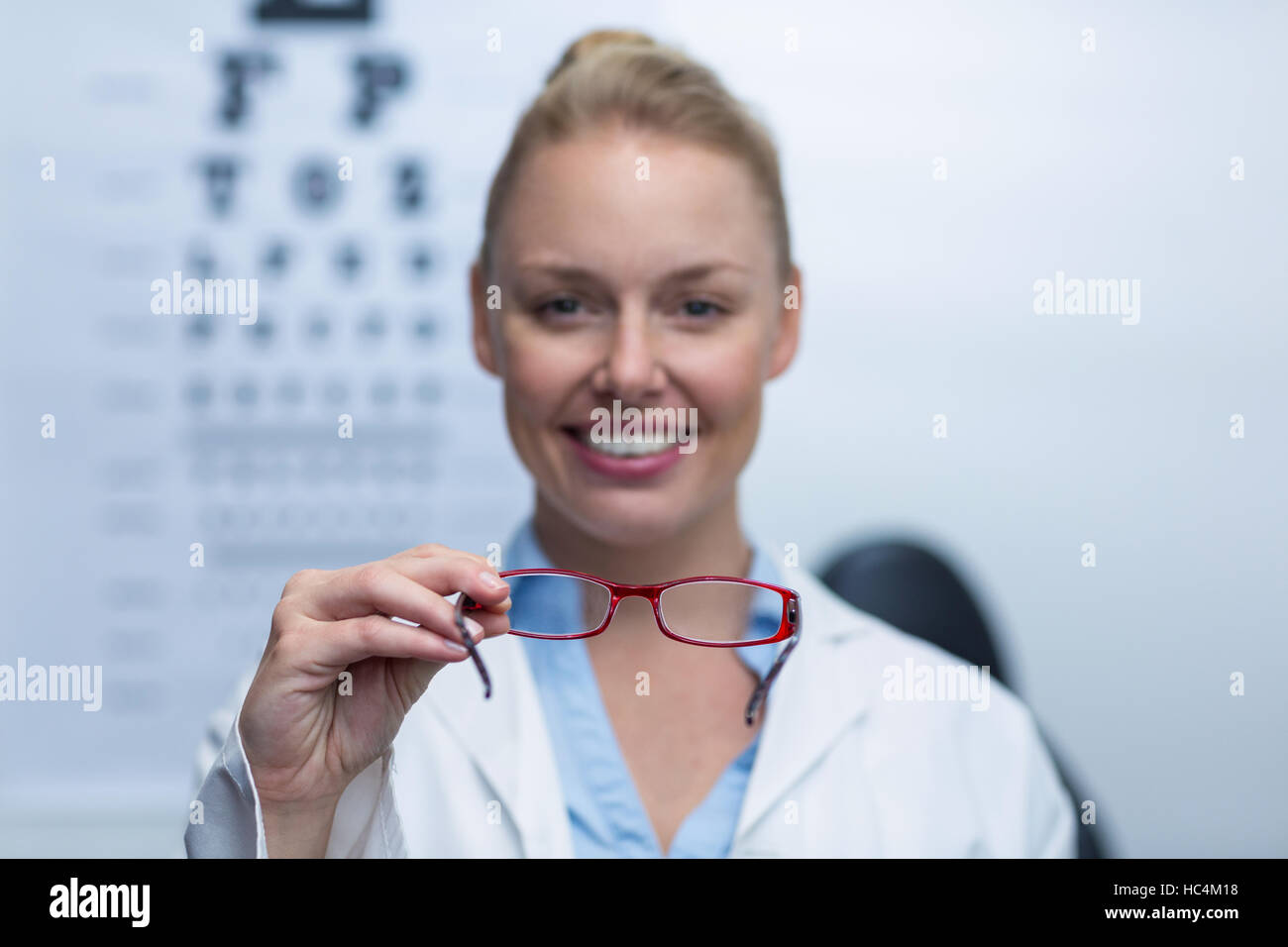 Smiling female optometrist holding spectacles Stock Photo - Alamy