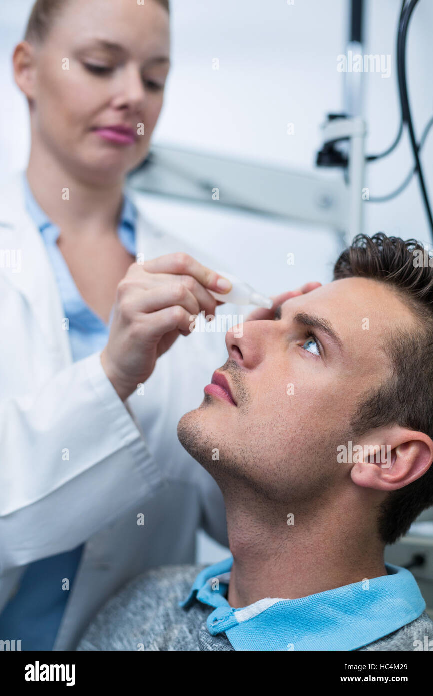 Female optometrist putting eye drop in patient eyes Stock Photo - Alamy