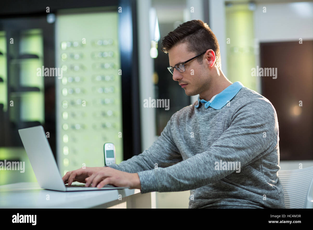 Customer using laptop in optical store Stock Photo - Alamy