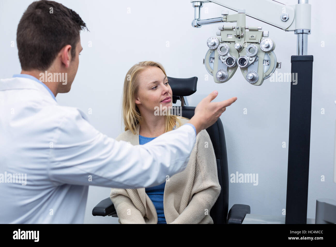 Optometrist interacting with female patient Stock Photo - Alamy