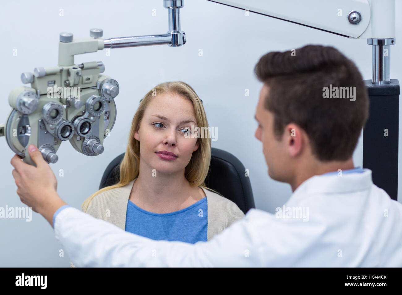 Optometrist interacting with female patient Stock Photo - Alamy