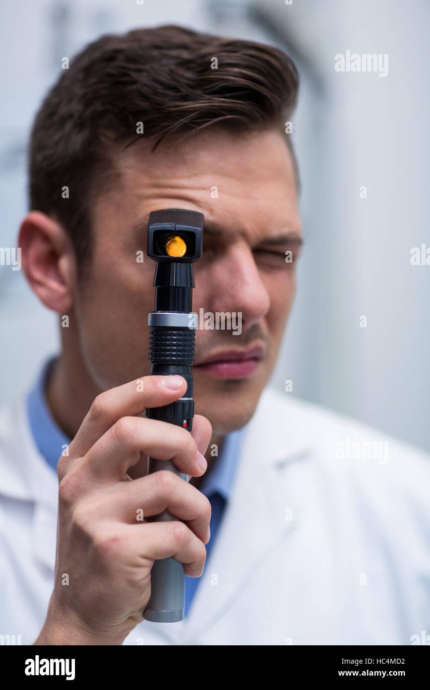 Close-up of optometrist looking through ophthalmoscope Stock Photo - Alamy