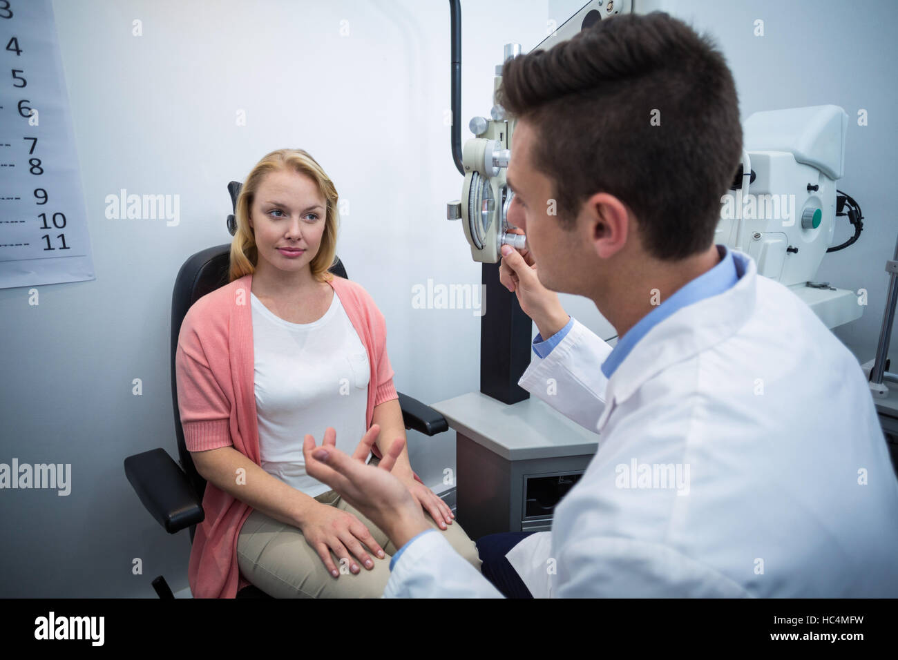 Optometrist assisting female patient Stock Photo - Alamy