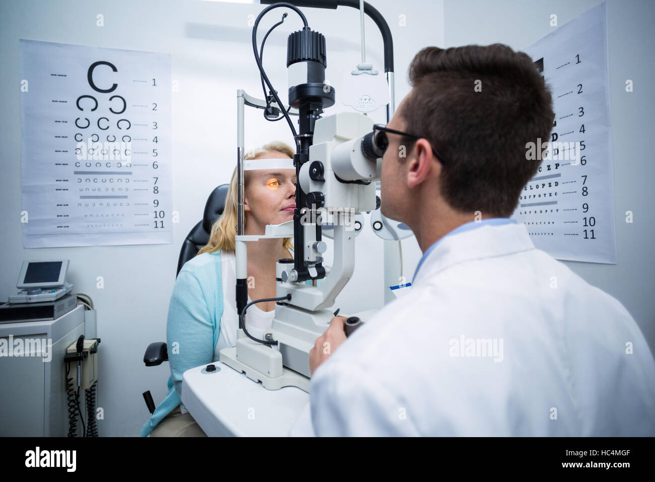 Optometrist examining female patient on slit lamp Stock Photo - Alamy