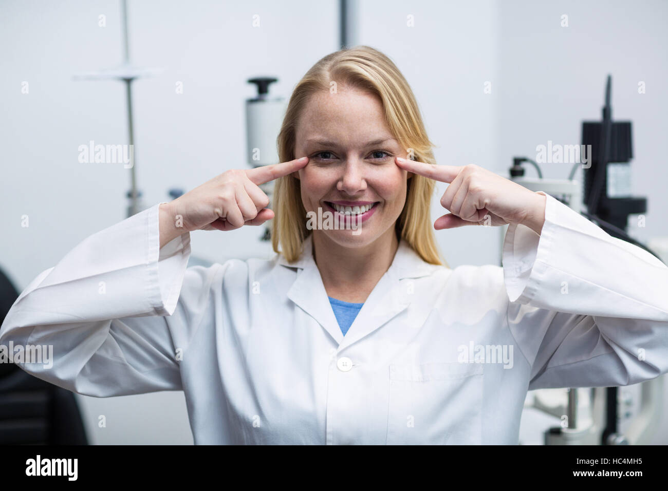 Female optometrist pointing at her eyes Stock Photo - Alamy