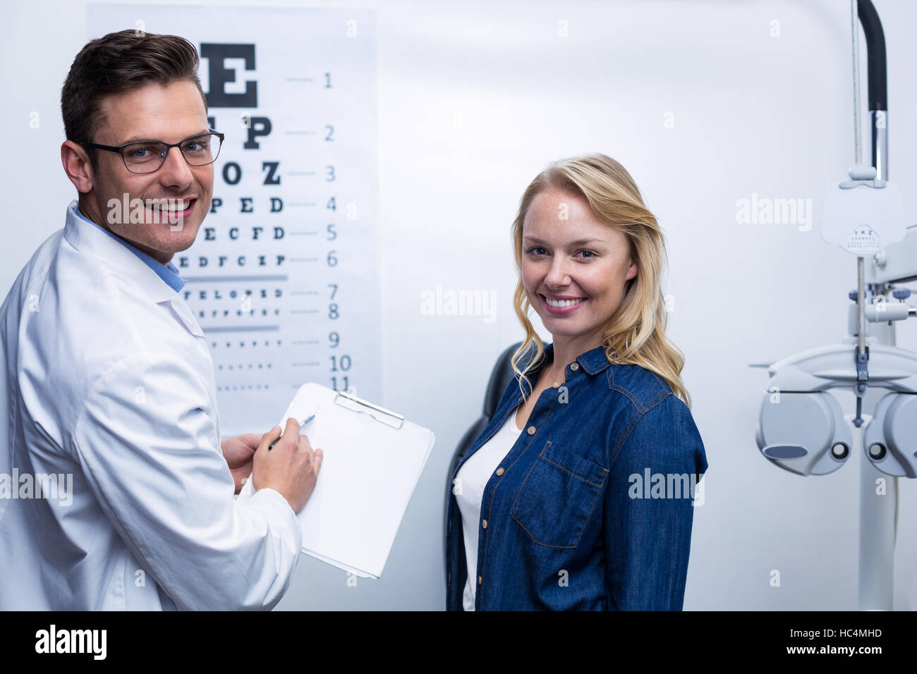 Optometrist discussing eye test report with female patient Stock Photo ...
