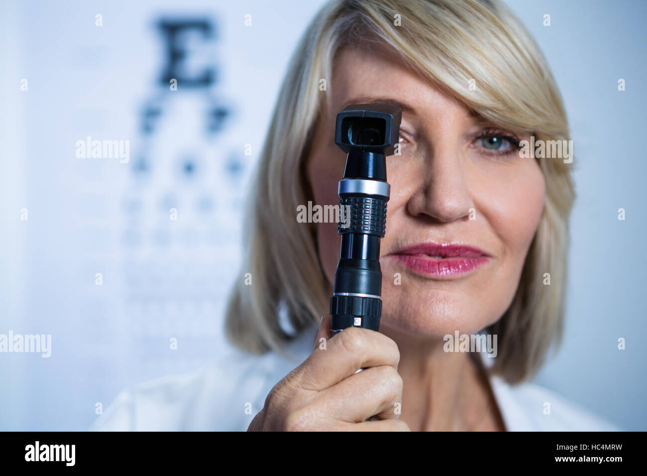 Female optometrist looking through ophthalmoscope Stock Photo - Alamy